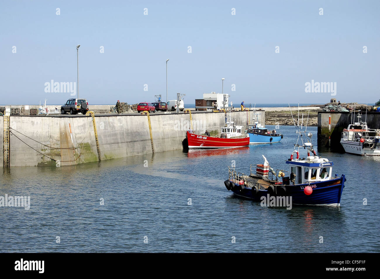 Seahouses Harbour, Northumberland with moored boats and one moving ...