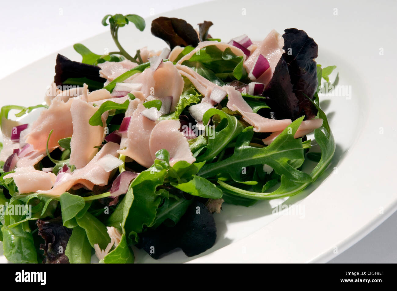 Mixed salad leaves, red onion and torn ham Stock Photo - Alamy