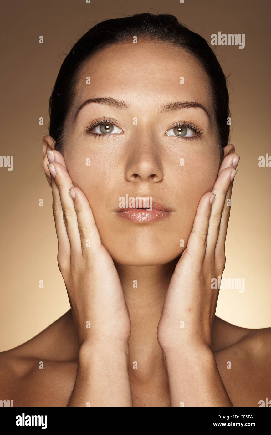 Female with her hands on her cheeks pulling her face up Stock Photo - Alamy