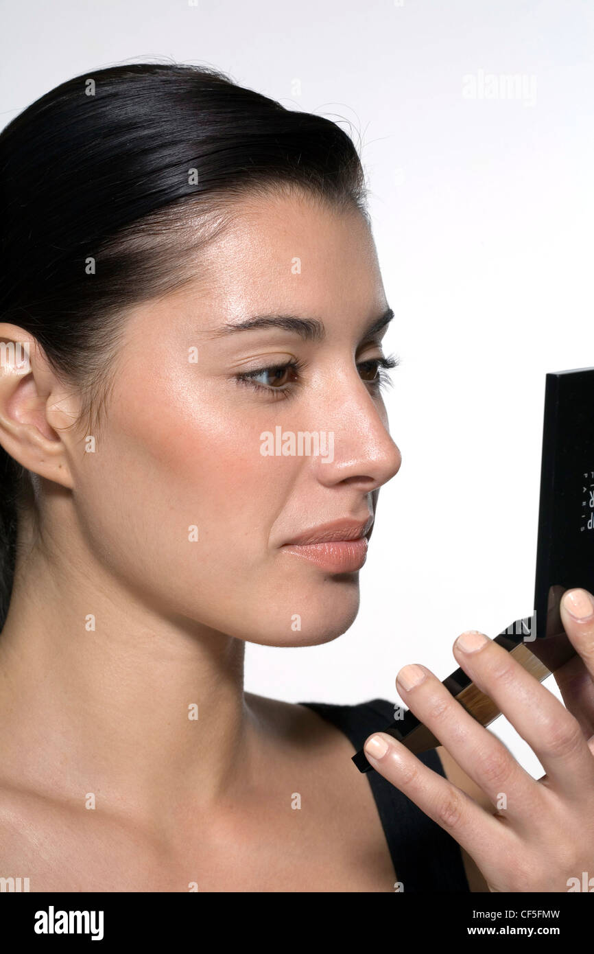 Female looking in a compact mirror Stock Photo - Alamy