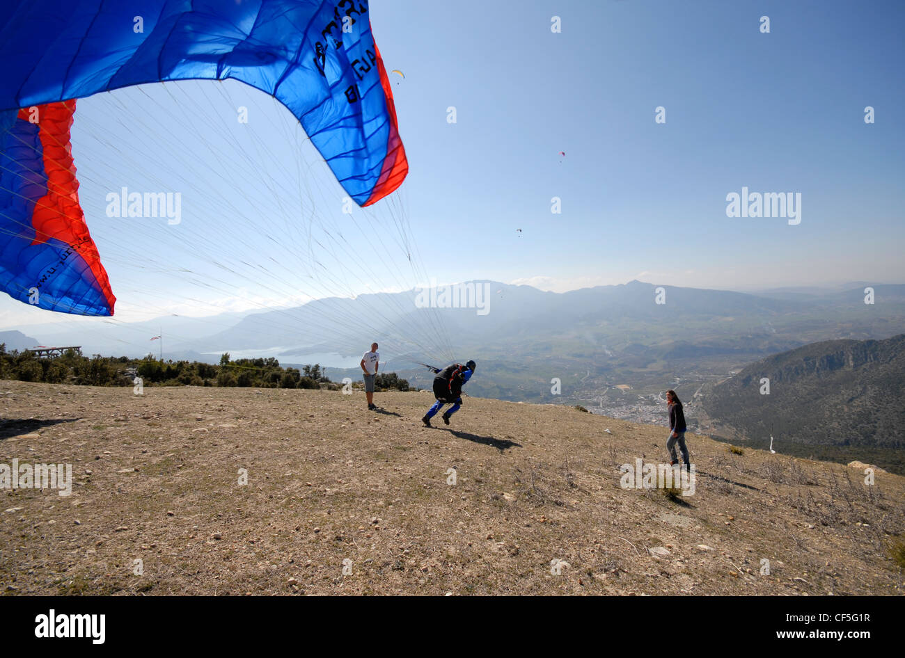 Paraglider pilot running to launch from top of hill Stock Photo - Alamy