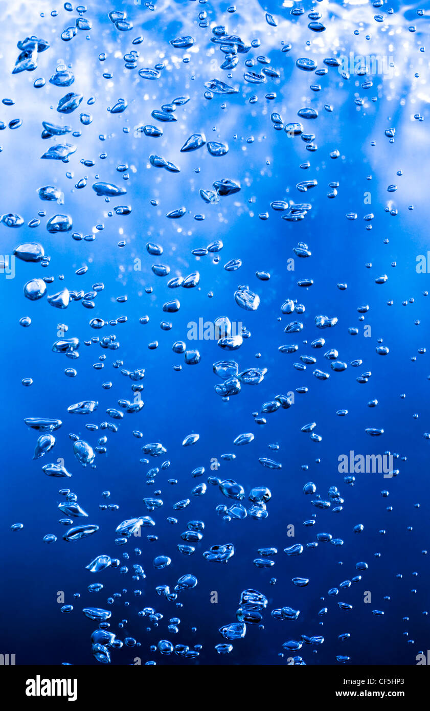 Side view of bubbles rising up in a blue liquid. Vertical shot Stock ...