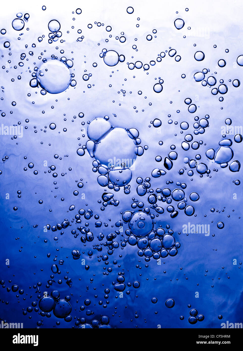 Side view of bubbles rising up in a blue liquid. Vertical shot Stock ...