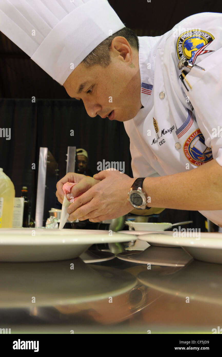 U.S. Army Sgt. Maj. Mark Morgan with the USA Culinary Team sets plates ...