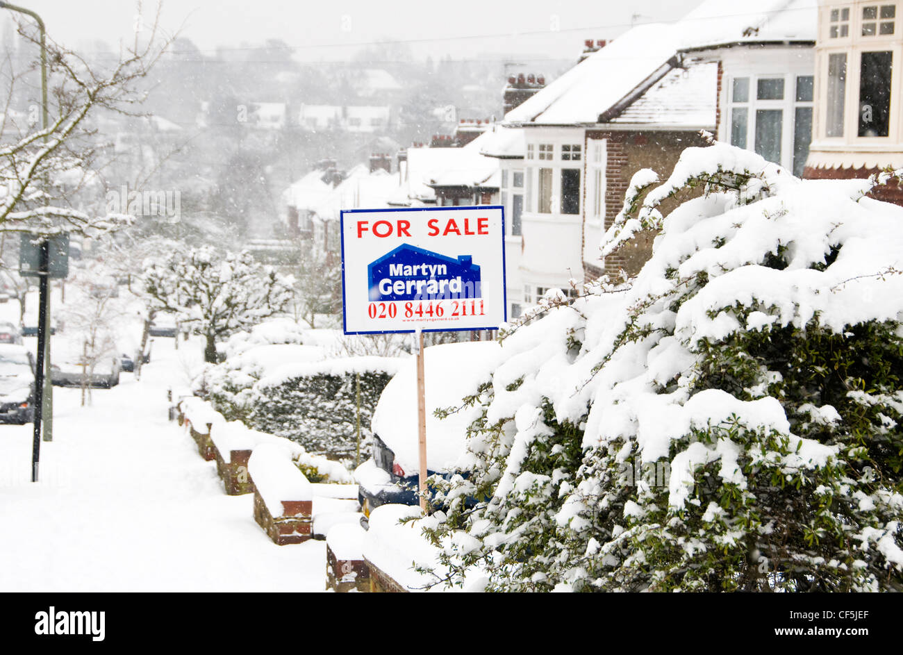 For Sale sign outside a house in a snow-covered street in North London ...