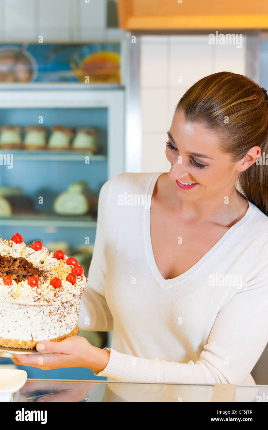 Female baker or pastry chef with torte in bakery Stock Photo - Alamy