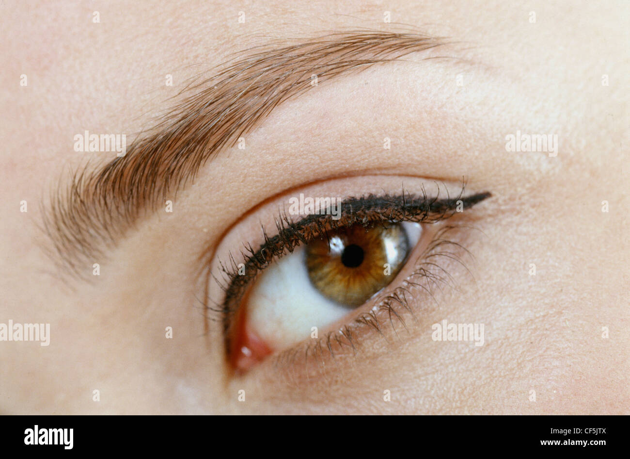 A close up image of female's face, wearing bold black eyeliner on her ...