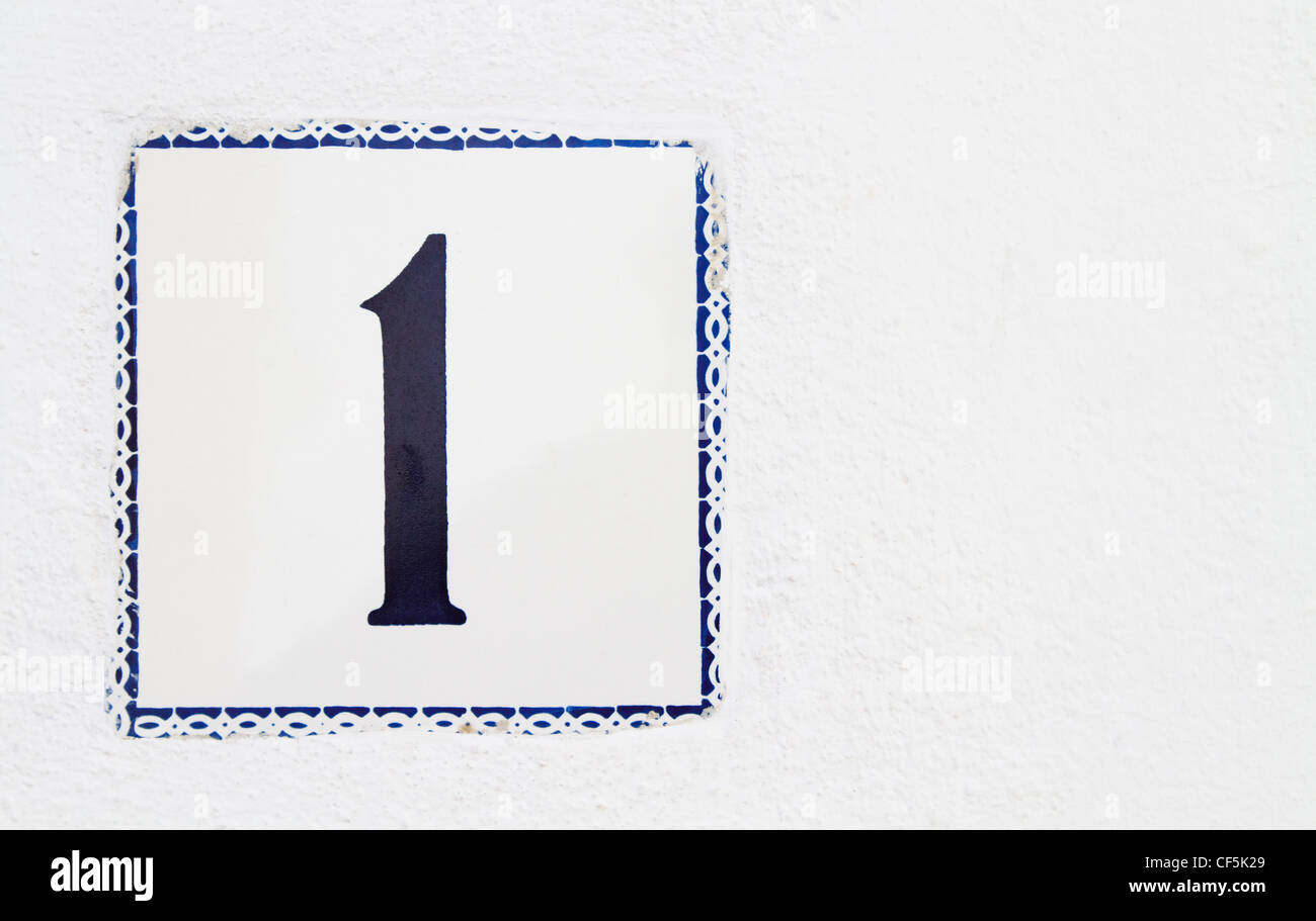 Spanish house number one wall tile on the outside of a white house ...