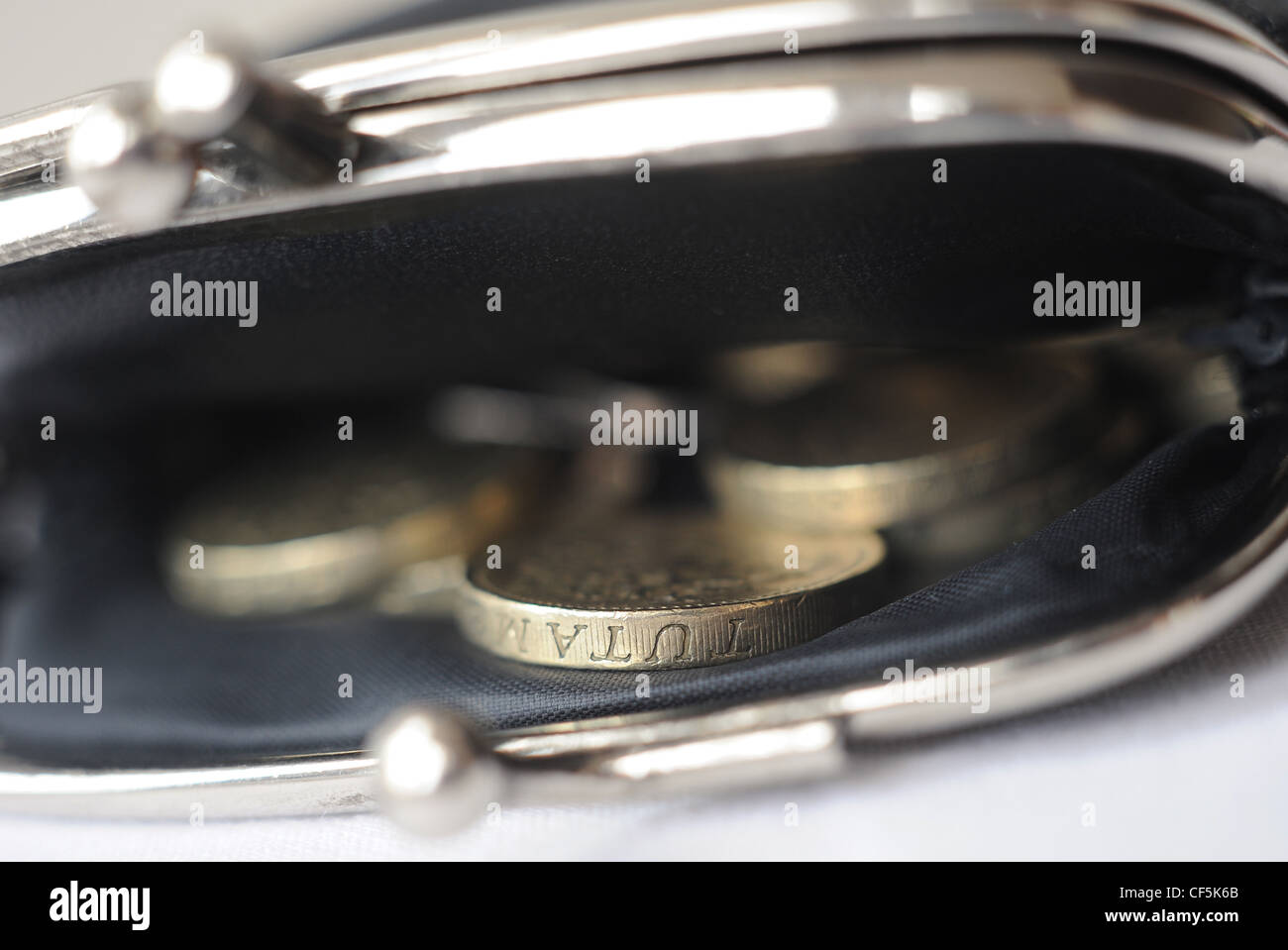 A close up image of a black coin purse with pound coins inside Stock ...