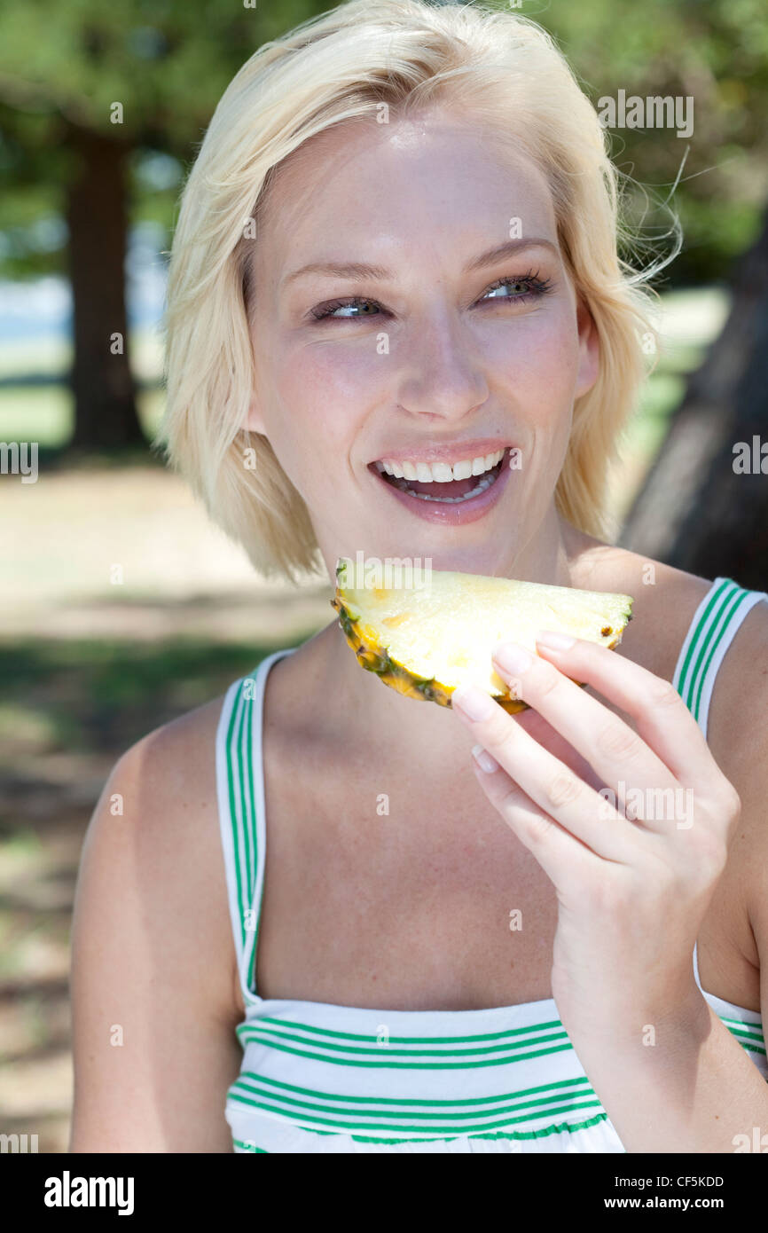 Female eating pineapple Stock Photo - Alamy