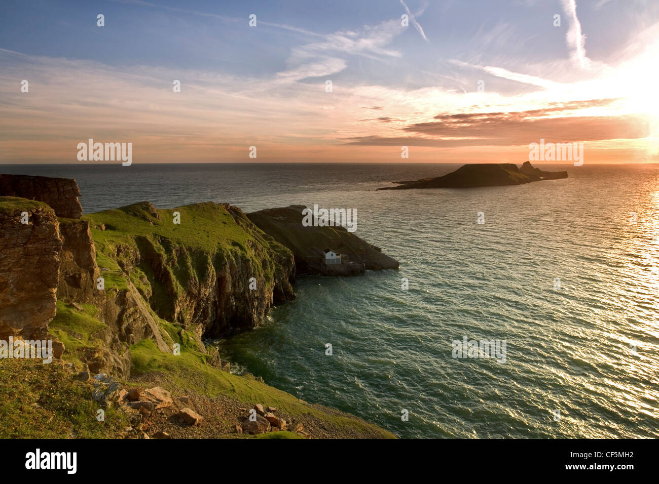A view toward Worms Head and the Kitchen Corner boat house in Rhossili ...