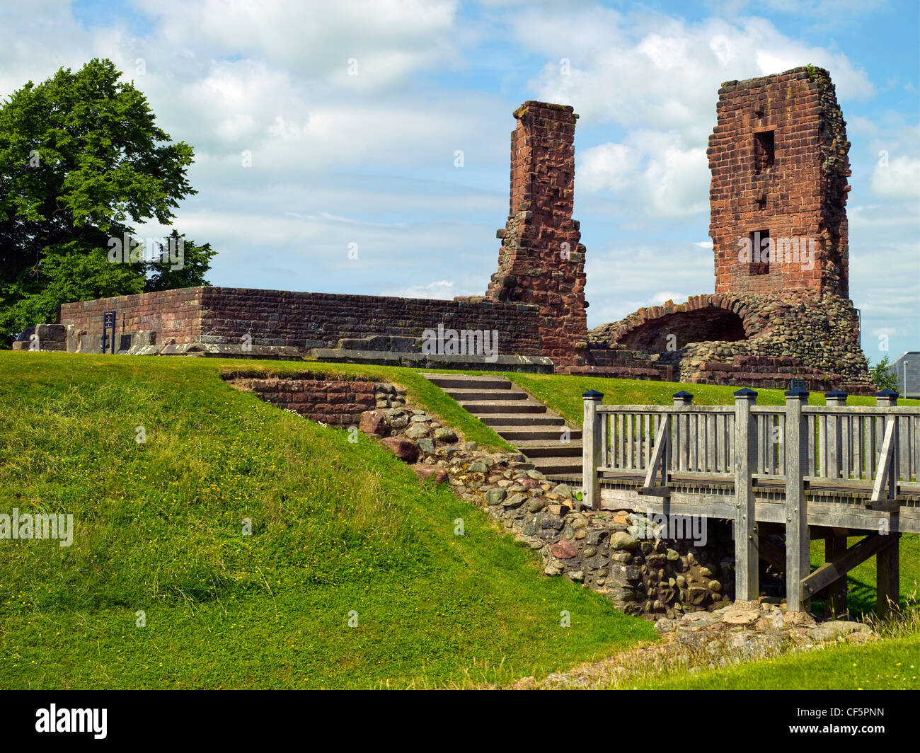 A wooden footbridge over a moat leading to the ruins of Penrith Castle ...