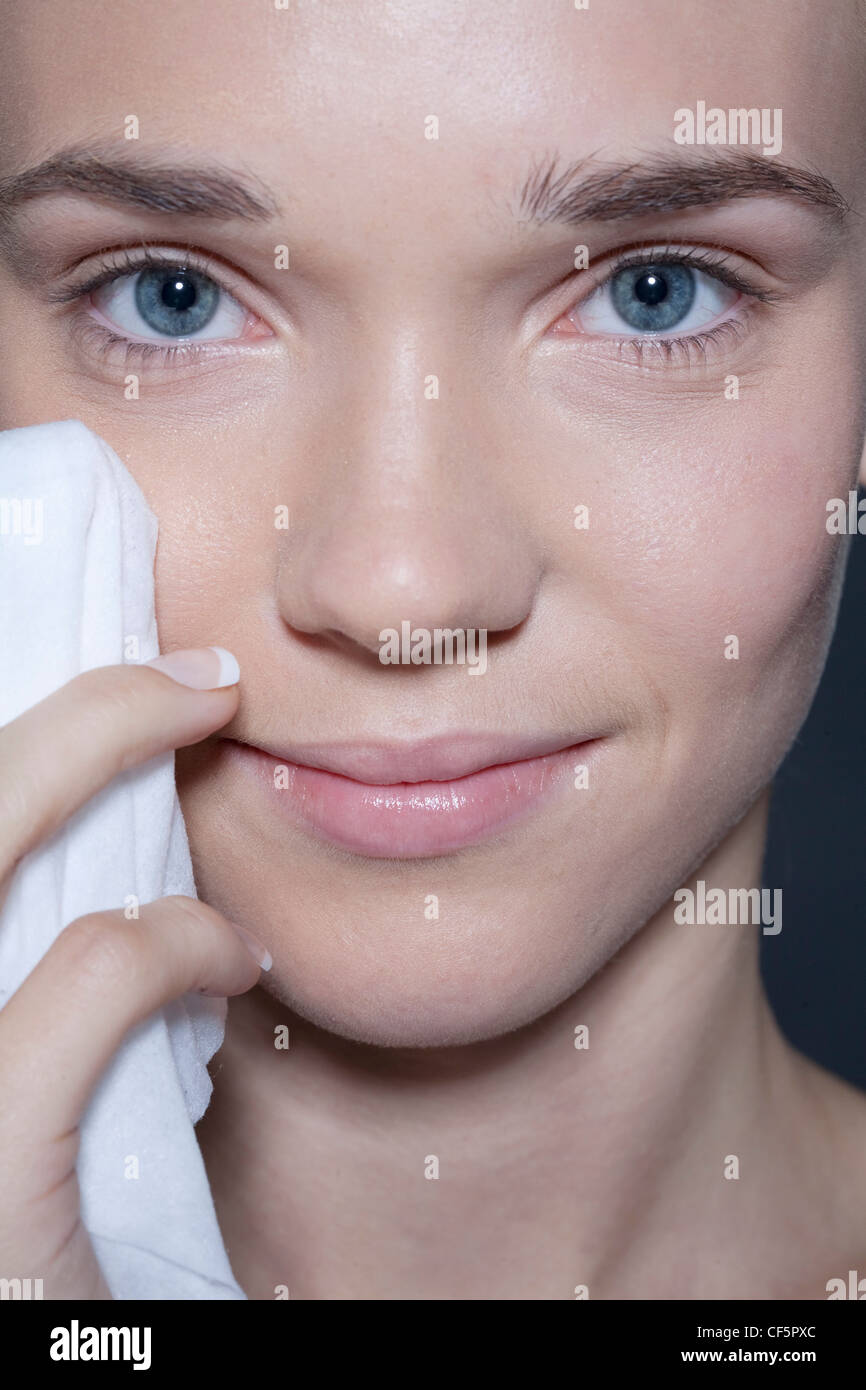 Step by Step Beauty and Make Up Cropped image of female's face, wiping ...
