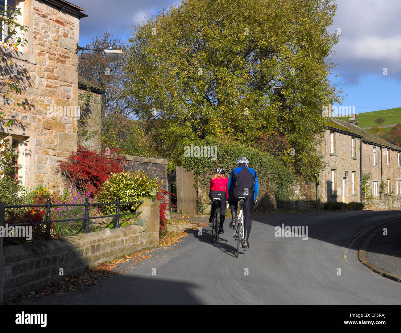 Cyclists riding through the village of Burnsall in Lower Wharfedale in ...