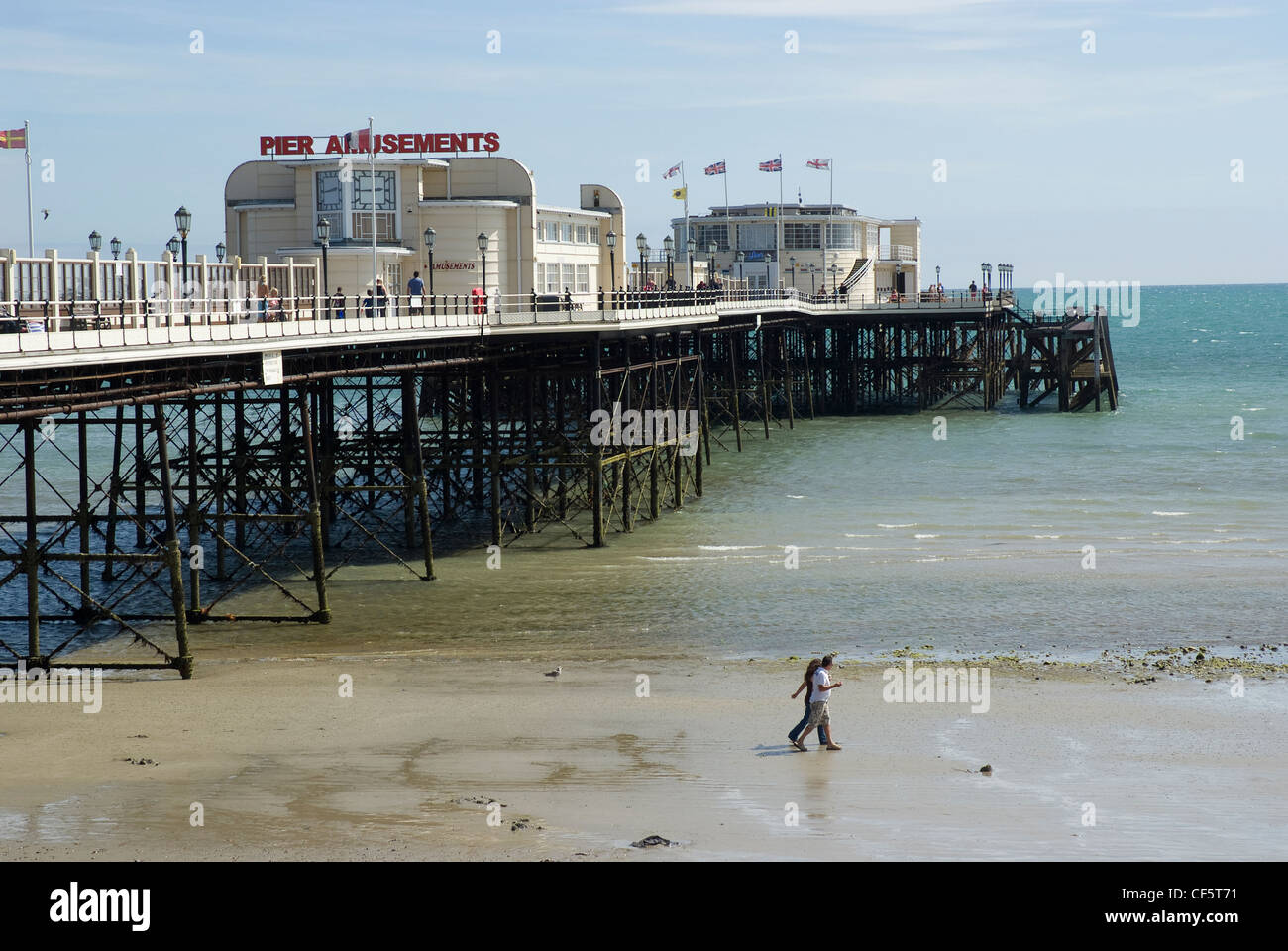A couple walking along the sandy beach below Worthing Pier Stock Photo ...