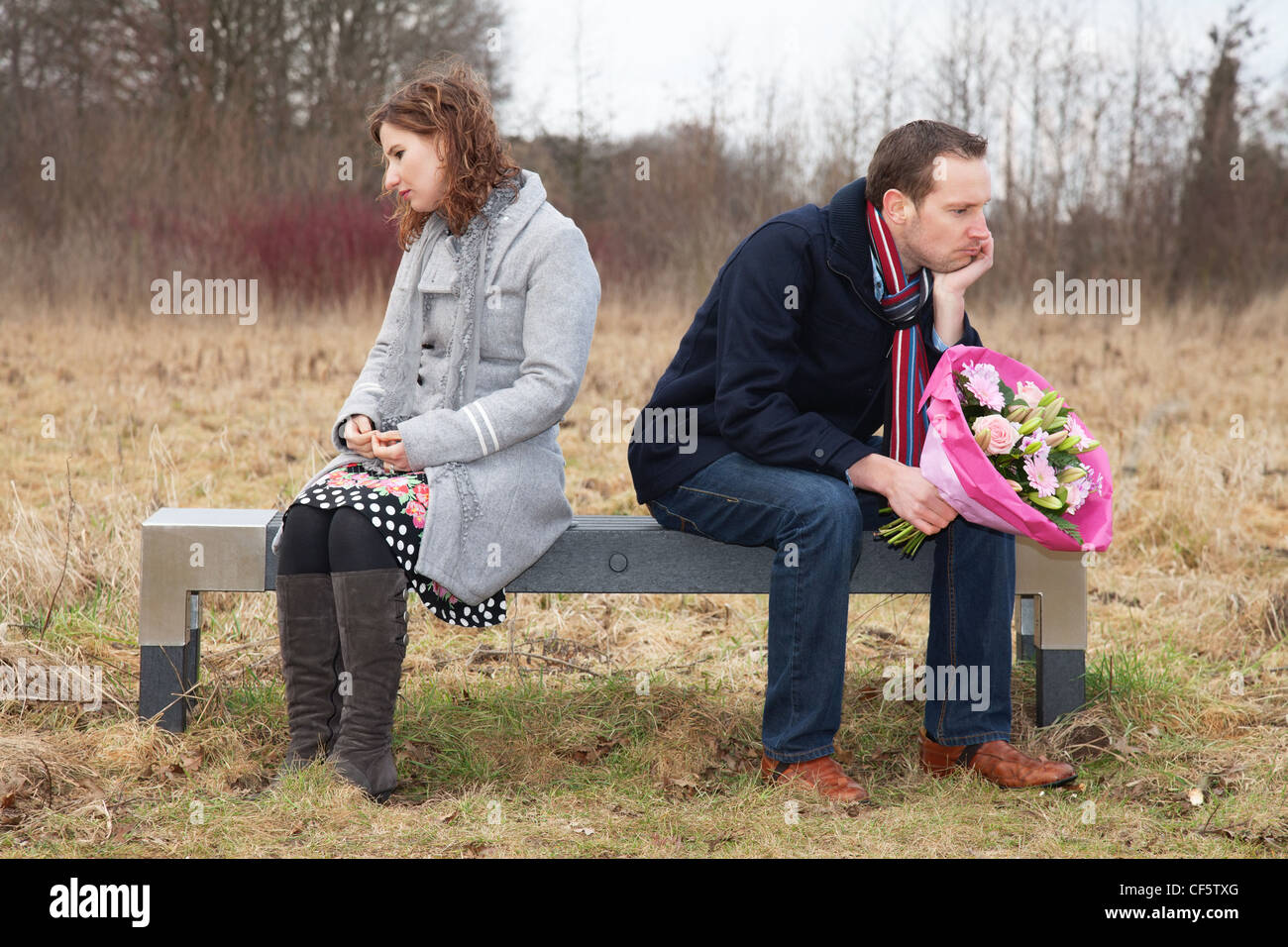 Disappointed couple in conflict sitting on bench Stock Photo - Alamy