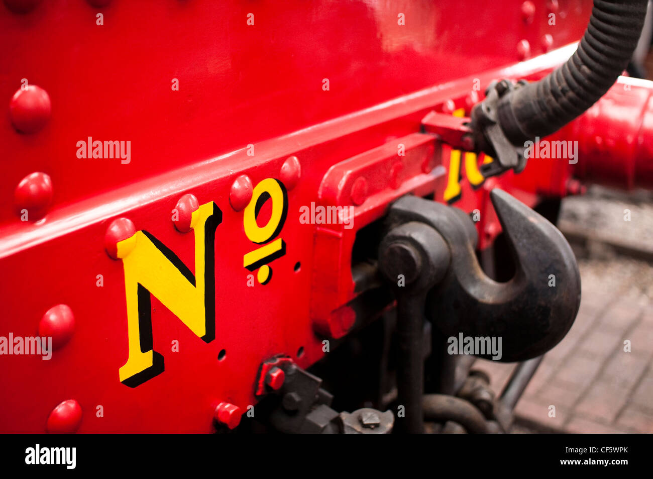 A close up of painted text on a red steam engine at sheds in Horsted ...