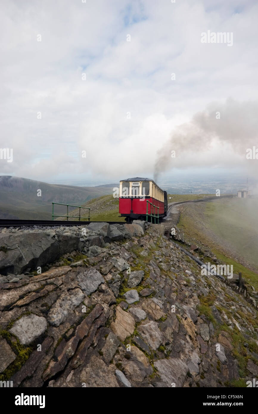 A Snowdon mountain railway steam train climbing a mountain on Snowdon ...