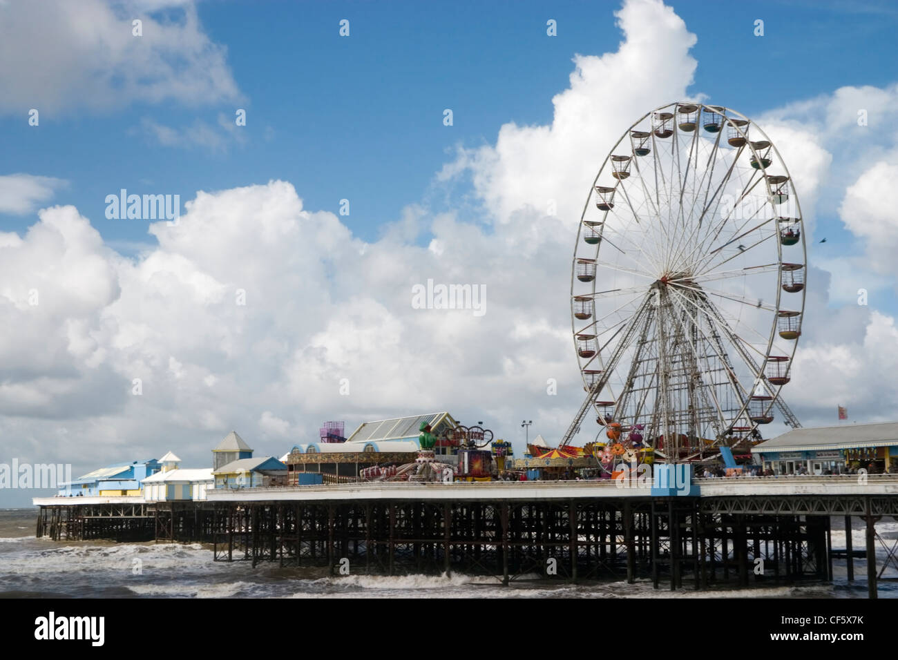 Seaside view in summer of a pier with pleasure rides at Blackpool. The ...