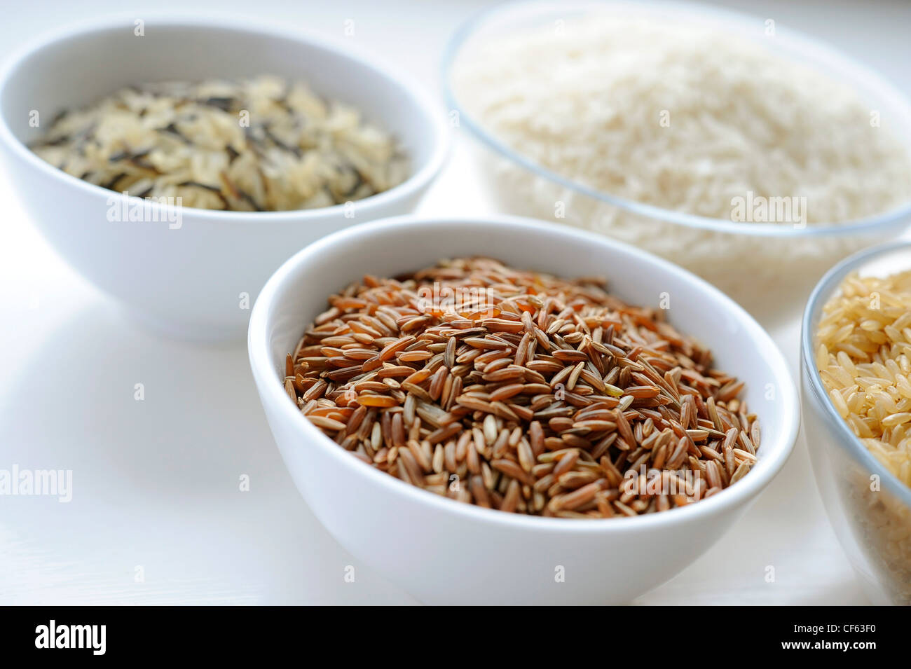 Four bowls of different varieties of rice, with a bowl of red rice in ...