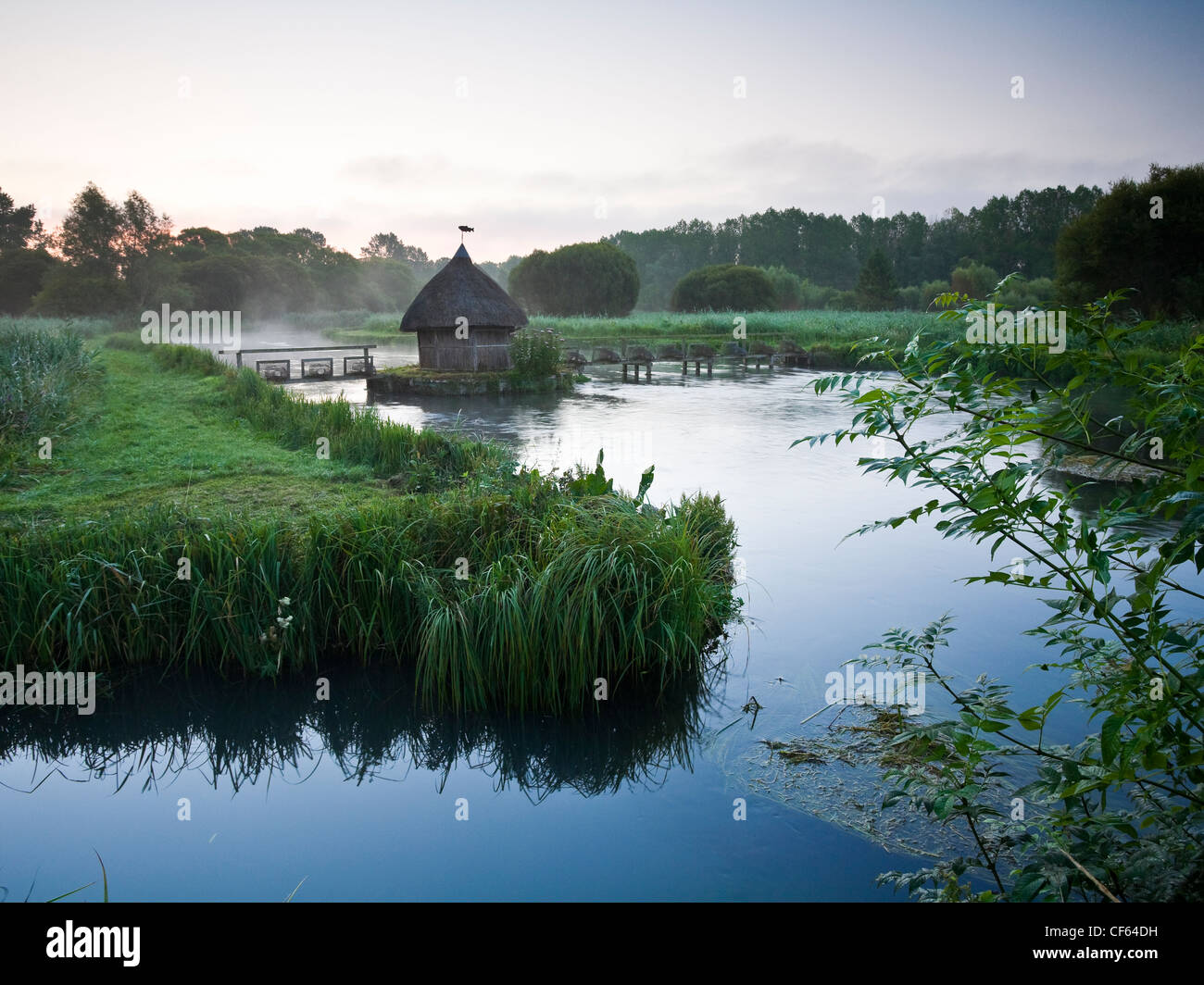 Thatched fishing hut and Eel traps on the River Test at Longstock Stock ...