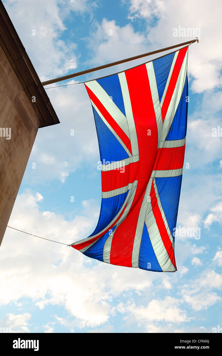 British flag waving in wind. in background of blue sky with white ...