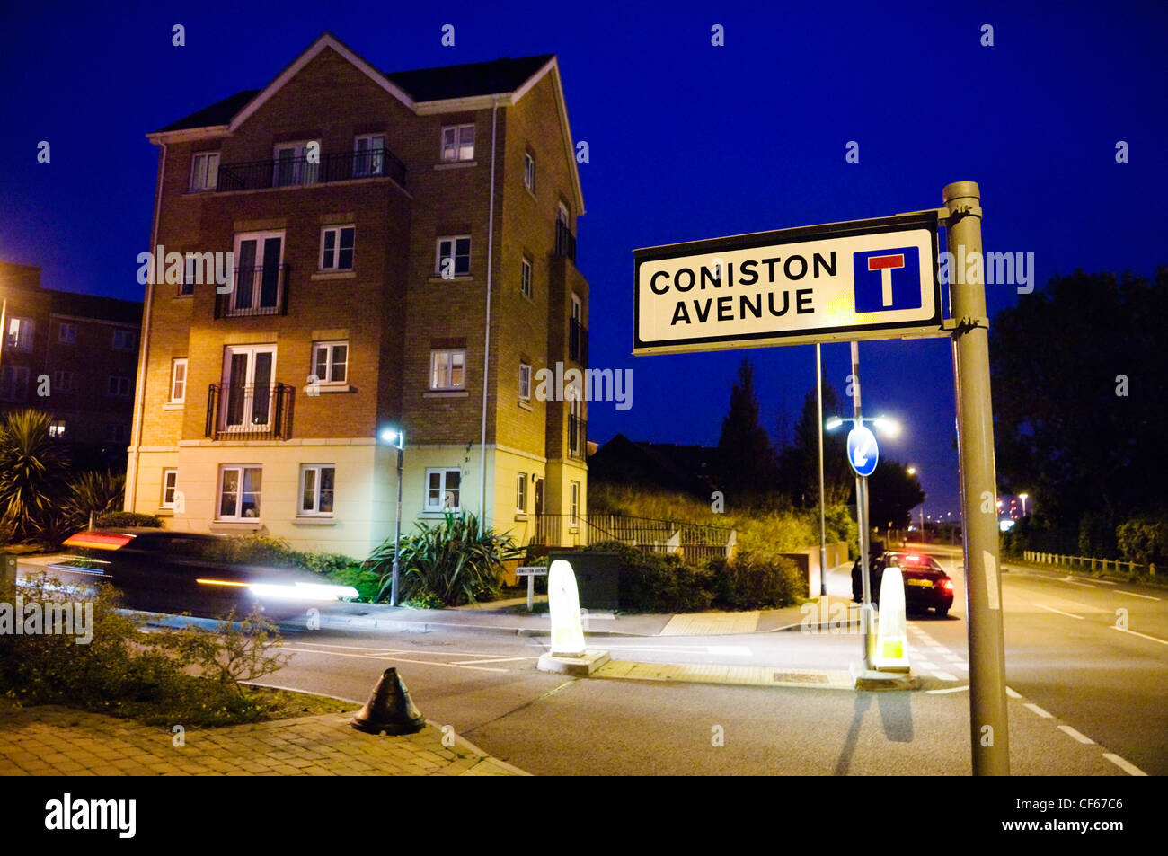 A road sign lit by a street lamp on a newly built housing estate in ...
