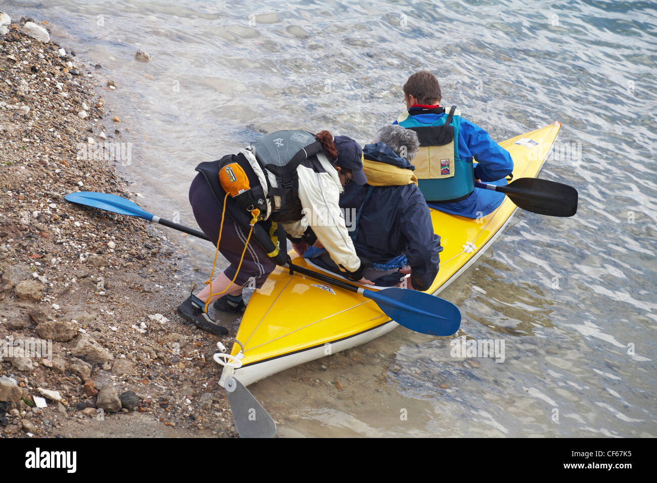 giving the kayak a push at Poole Harbour in February Stock Photo - Alamy