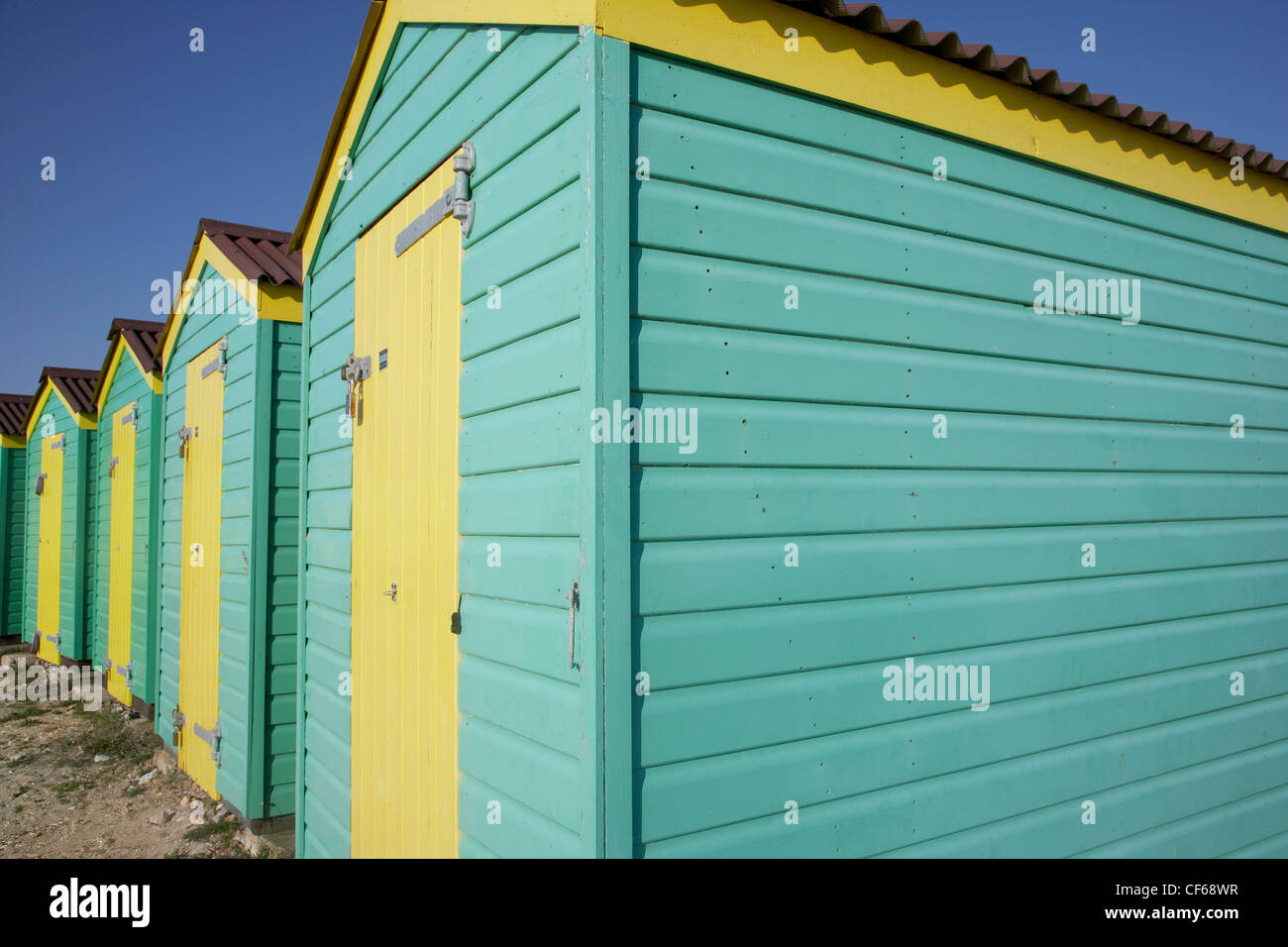 A view along brightly coloured beach huts Stock Photo - Alamy