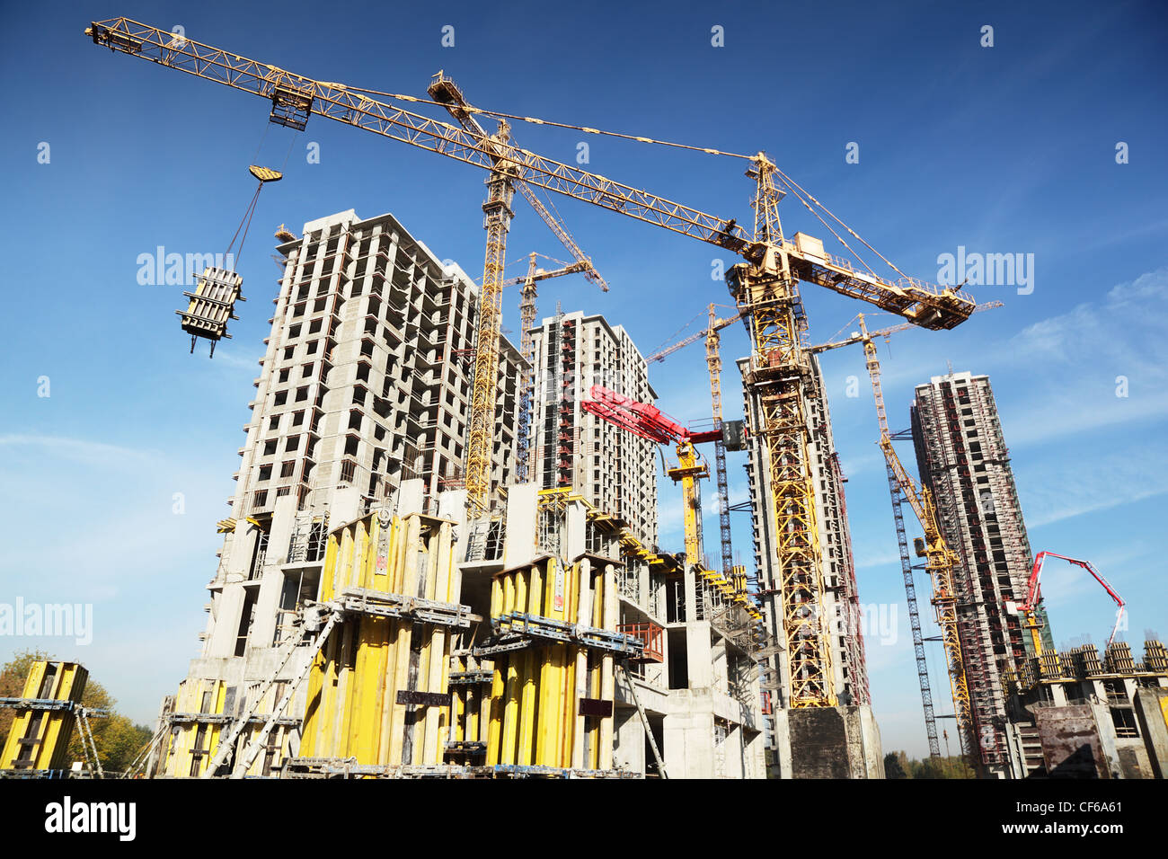 Working on place with many tall buildings under construction and cranes ...