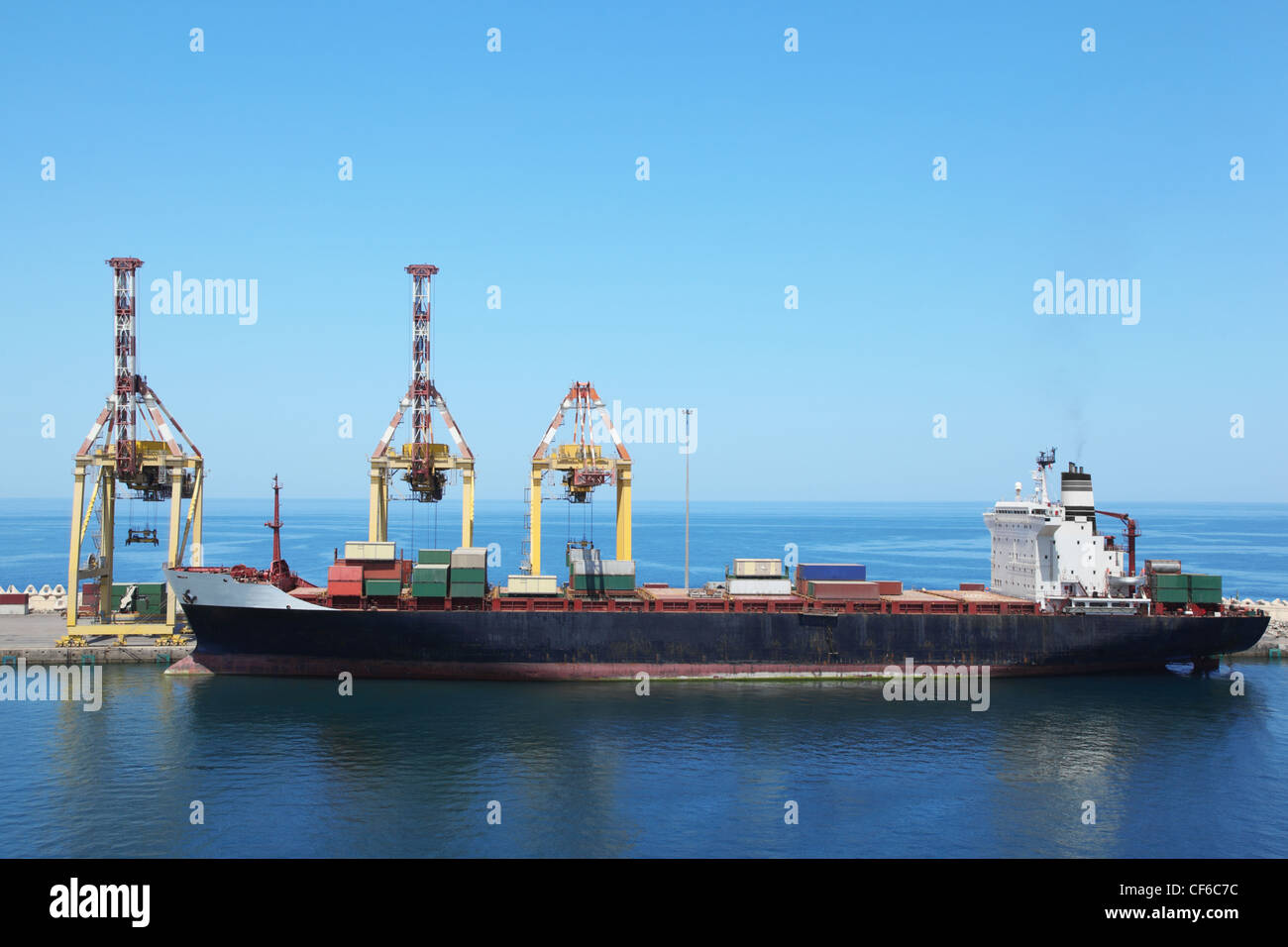 big merchant ship with cargos on a board at its moorings in port Stock ...
