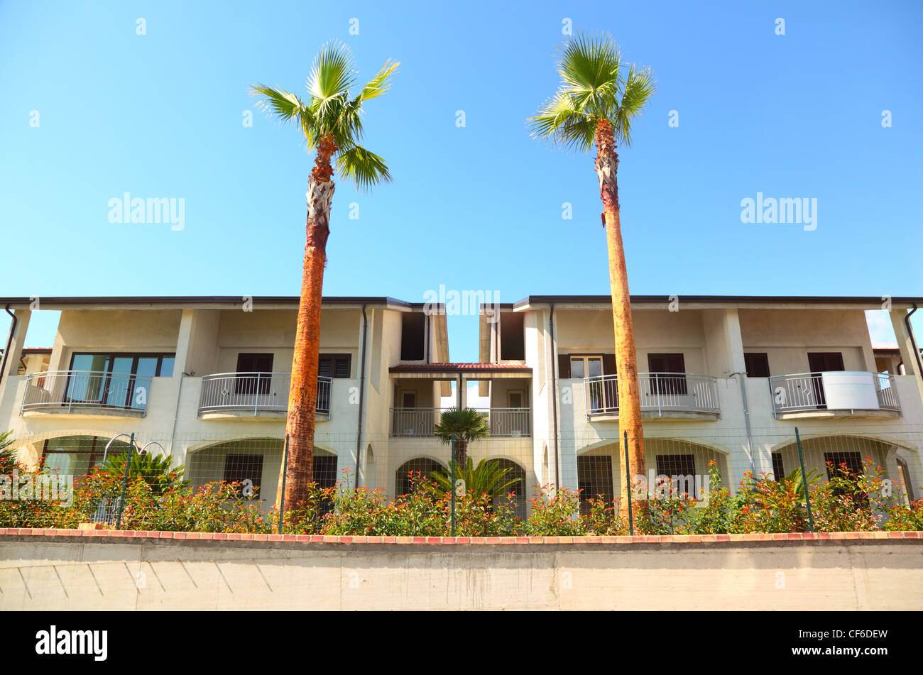 Two luxury cottages with balcony and garden with palm trees are fenced ...