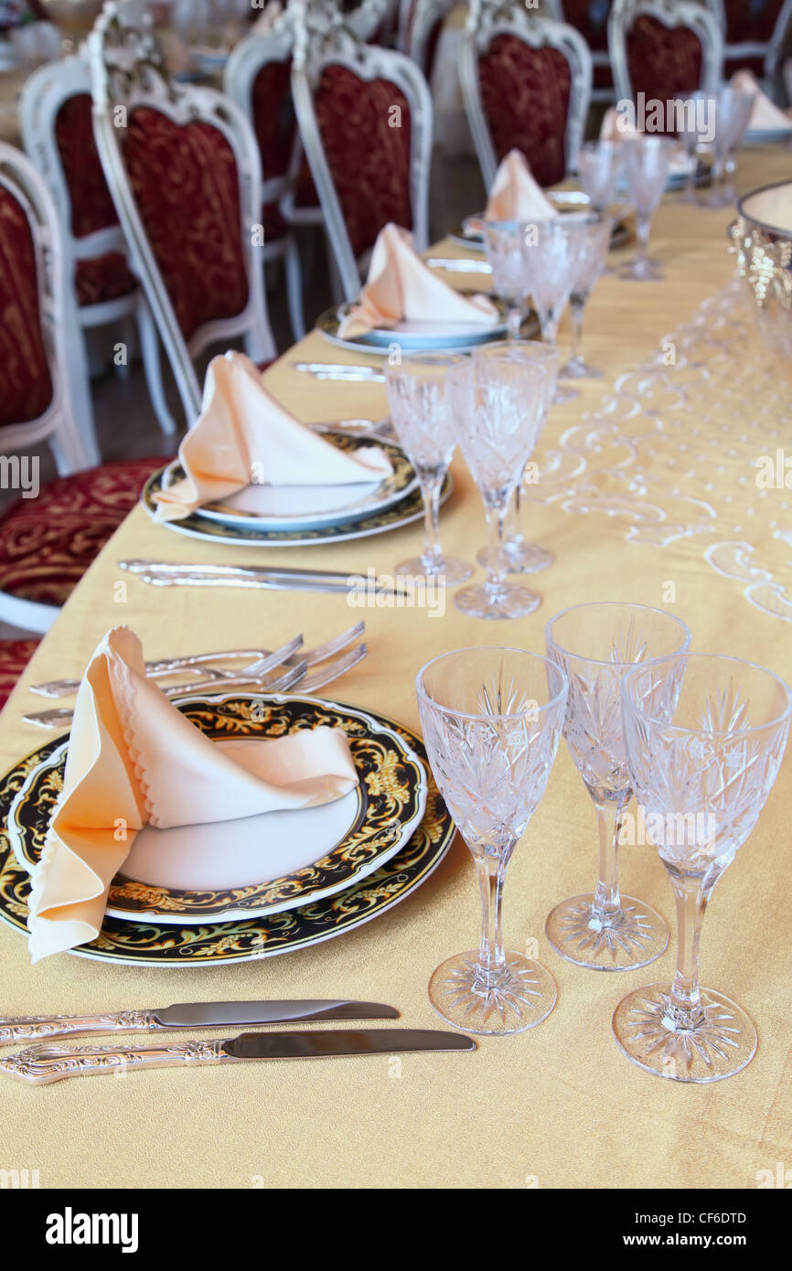 Three goblets, two knives and two plates with placemat at the dinner ...