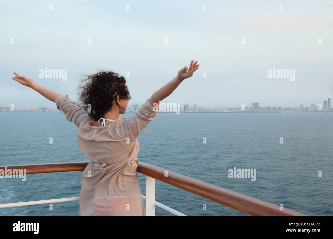 Wind in girl face. She standing on deck and watching the city at ...