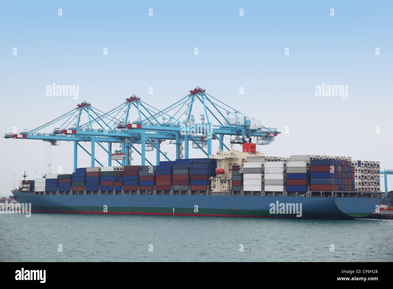 Big cargo boat docked to industrial port with several blue cranes Stock ...