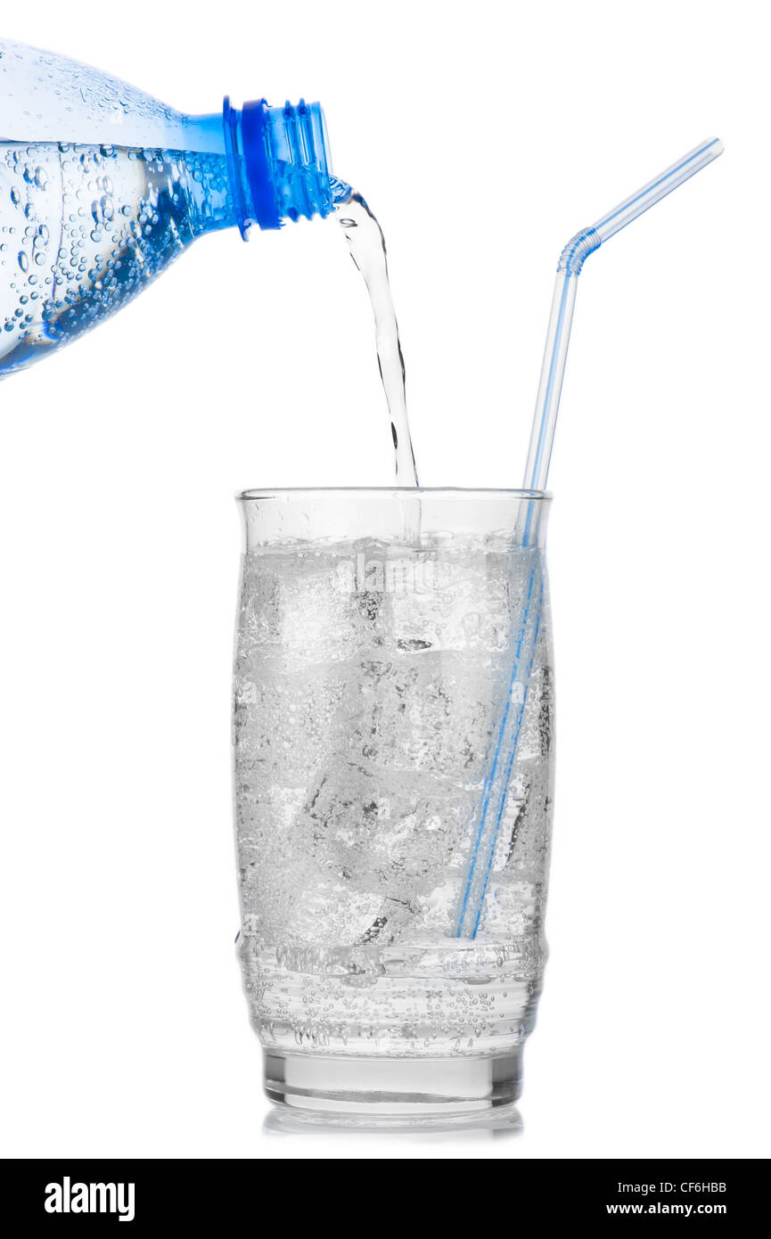 Iced mineral water pouring from plastic bottle into a glass with ice ...