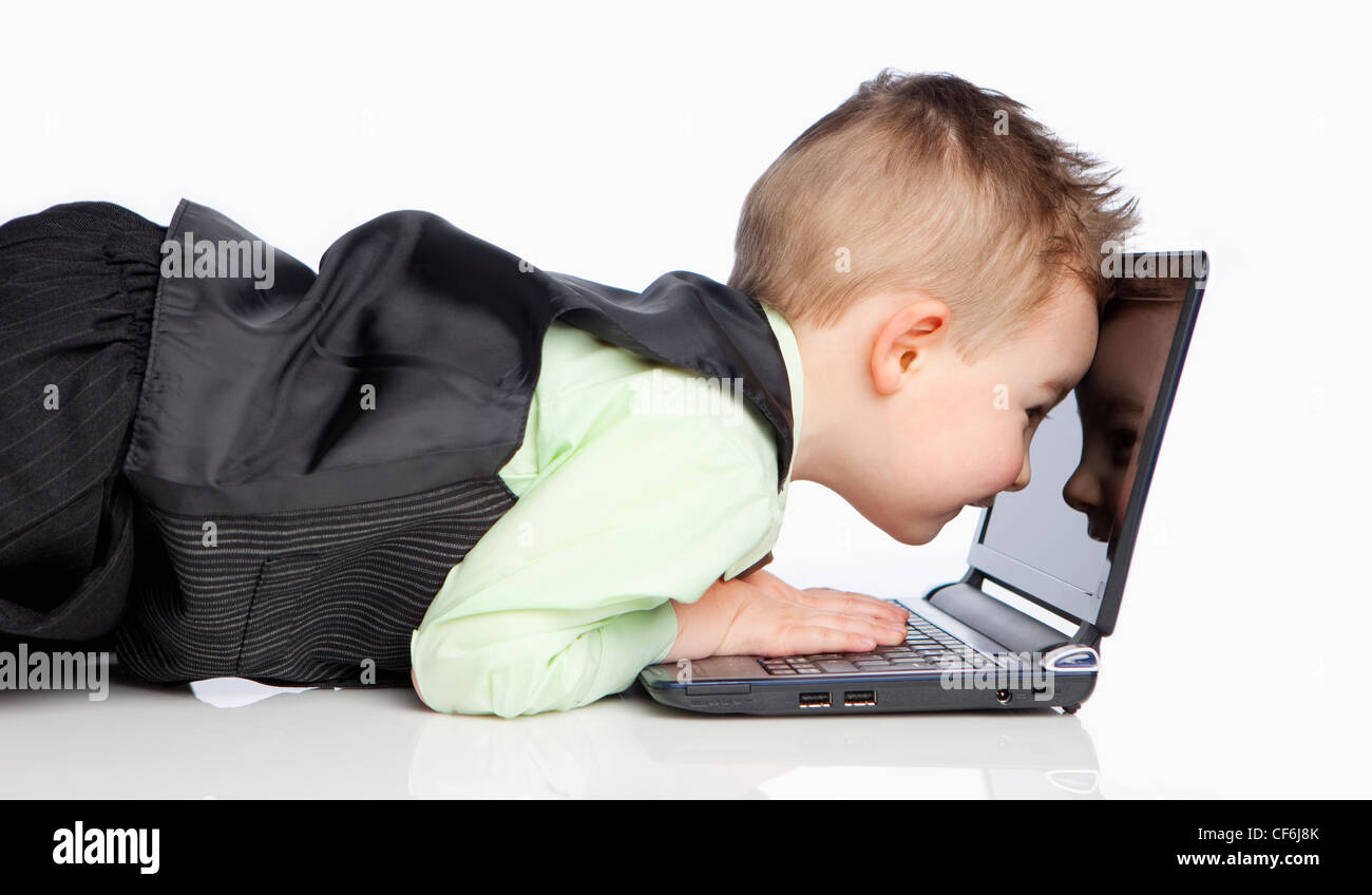 A Young Boy Dressed In A Suit Sees The Reflection Of His Face In The ...