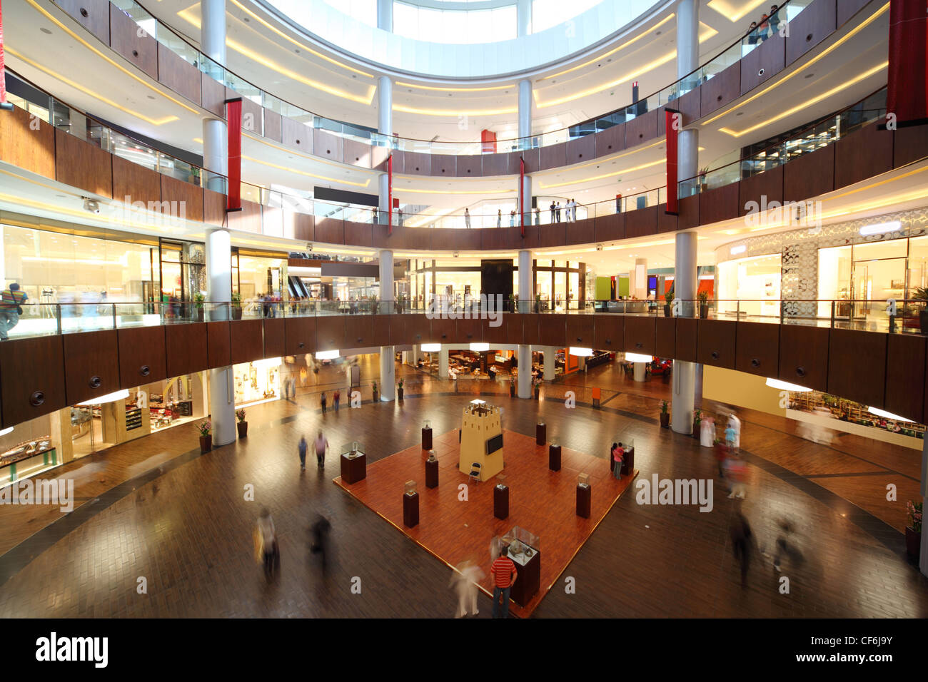 circle shopping center with four floors and columns, people in motion ...