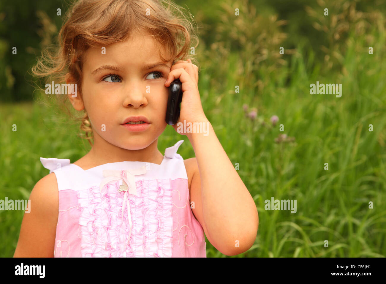 beautiful little girl in pink dress talking on cell phone outdoors ...