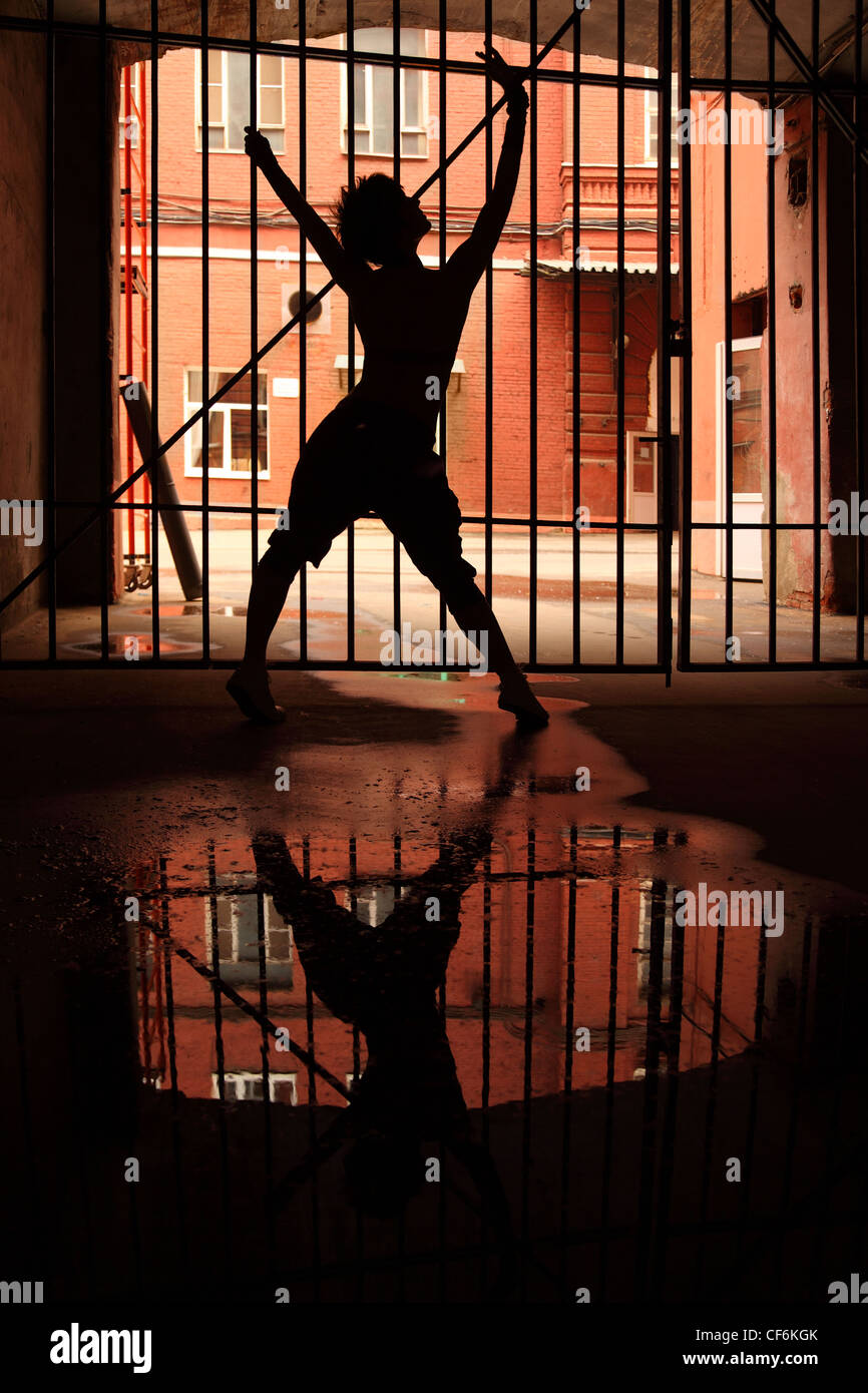 Silhouette of dancing girl in the dark, she kept behind lattice ...
