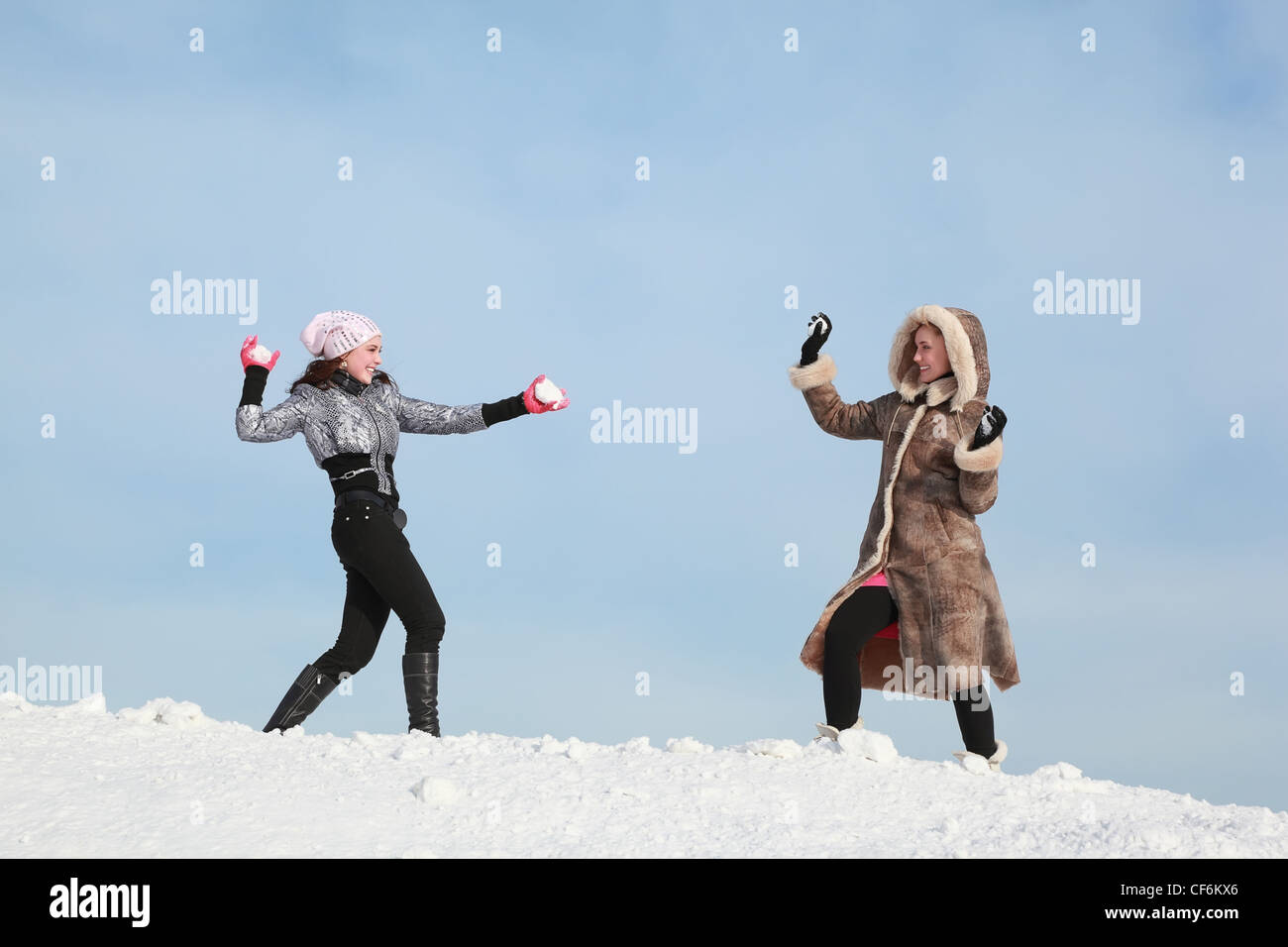 Two girls play snowballs and laugh Stock Photo - Alamy