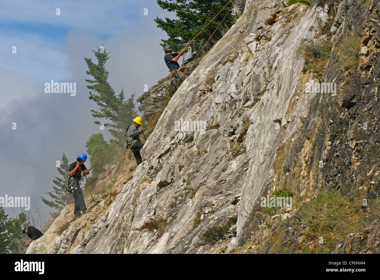 Cleaning up a rock slide from a mountain roadway Stock Photo - Alamy