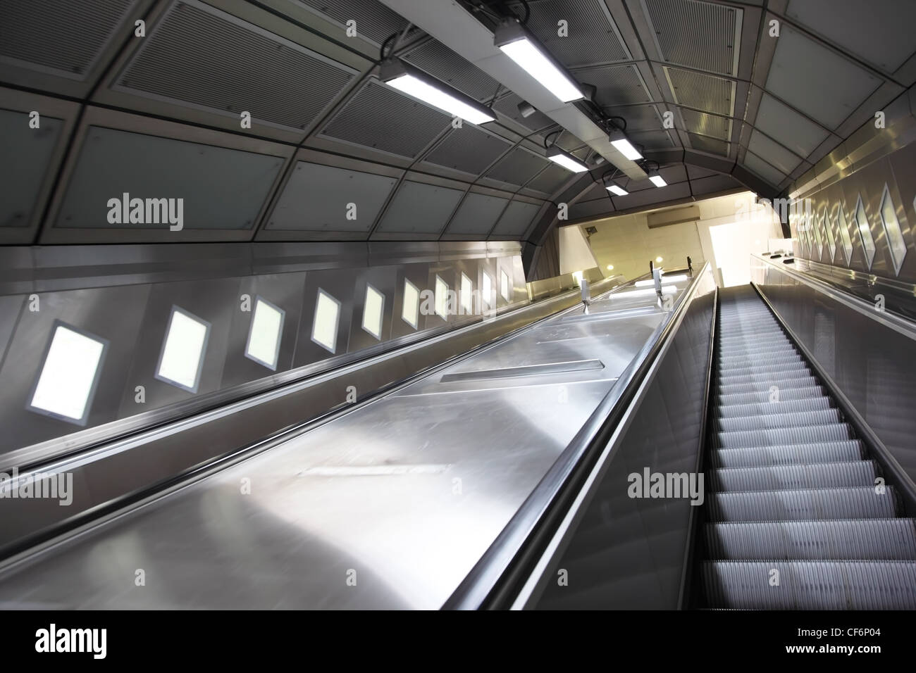 Rise on an escalator in the underground metal corridor Stock Photo - Alamy