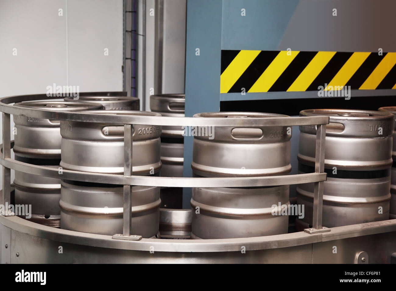 several aluminum beer barrels move on the conveyor. blue wall is ...