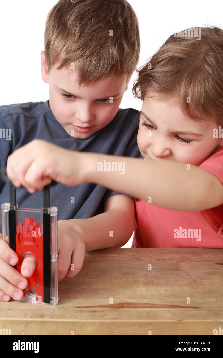 Brother and sister play with little guillotine Stock Photo - Alamy