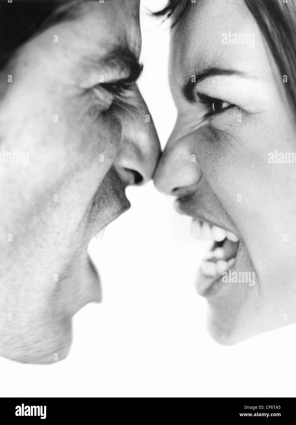 Couple arguing face to face pushing noses against each other shouting ...