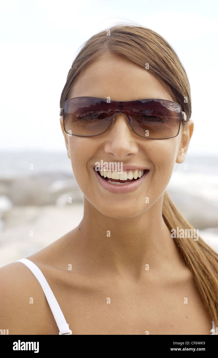 Female brunette hair off face wearing white vest top and sunglasses ...