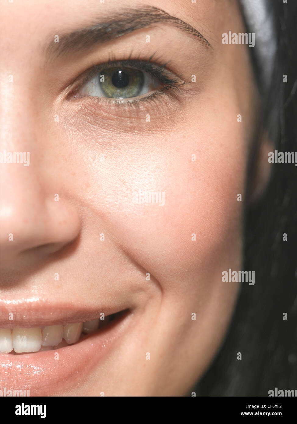 Cropped face of female with dark brunette hair held off face with white ...