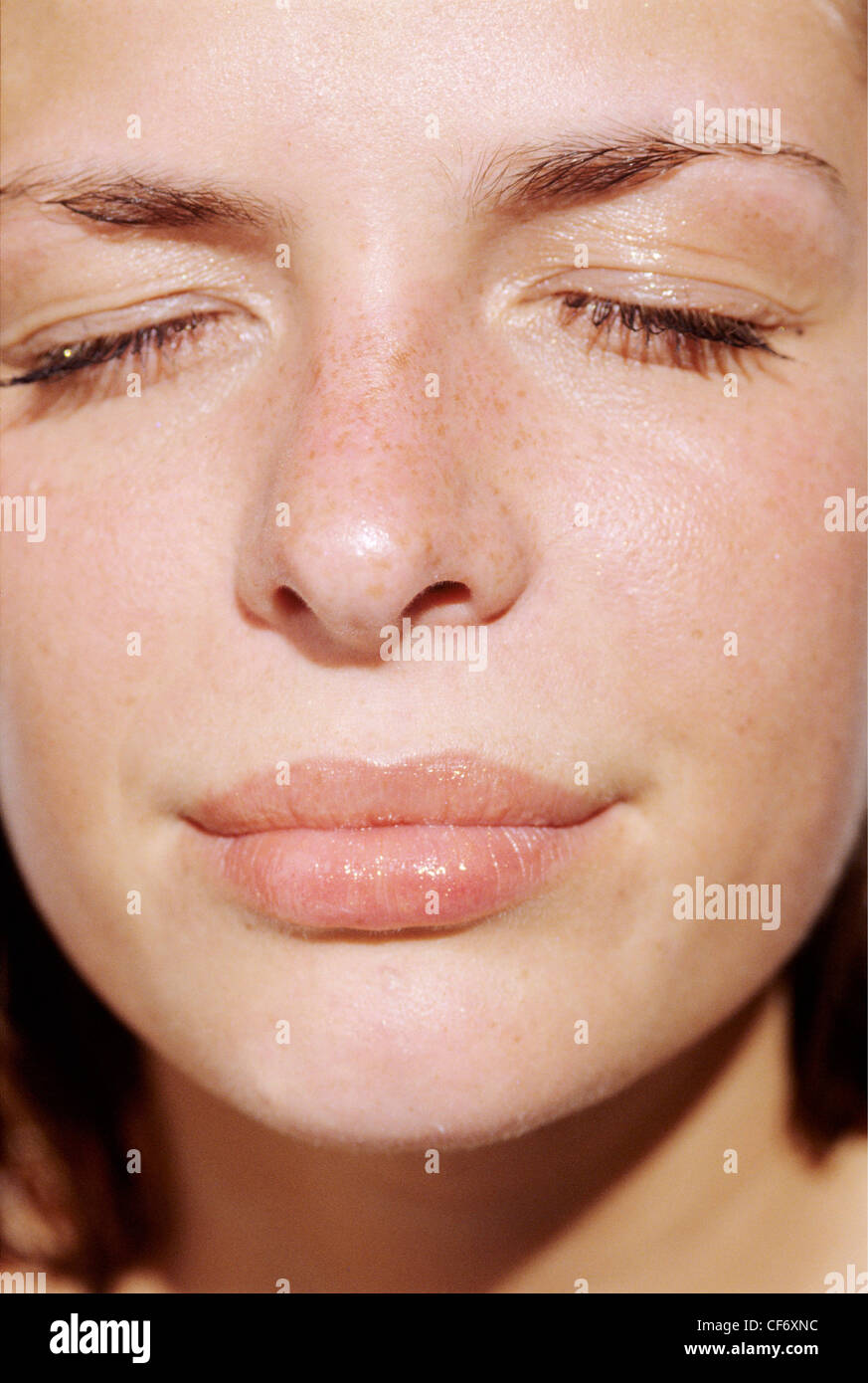 Close up face of Female unsmiling with eyes shut Stock Photo - Alamy