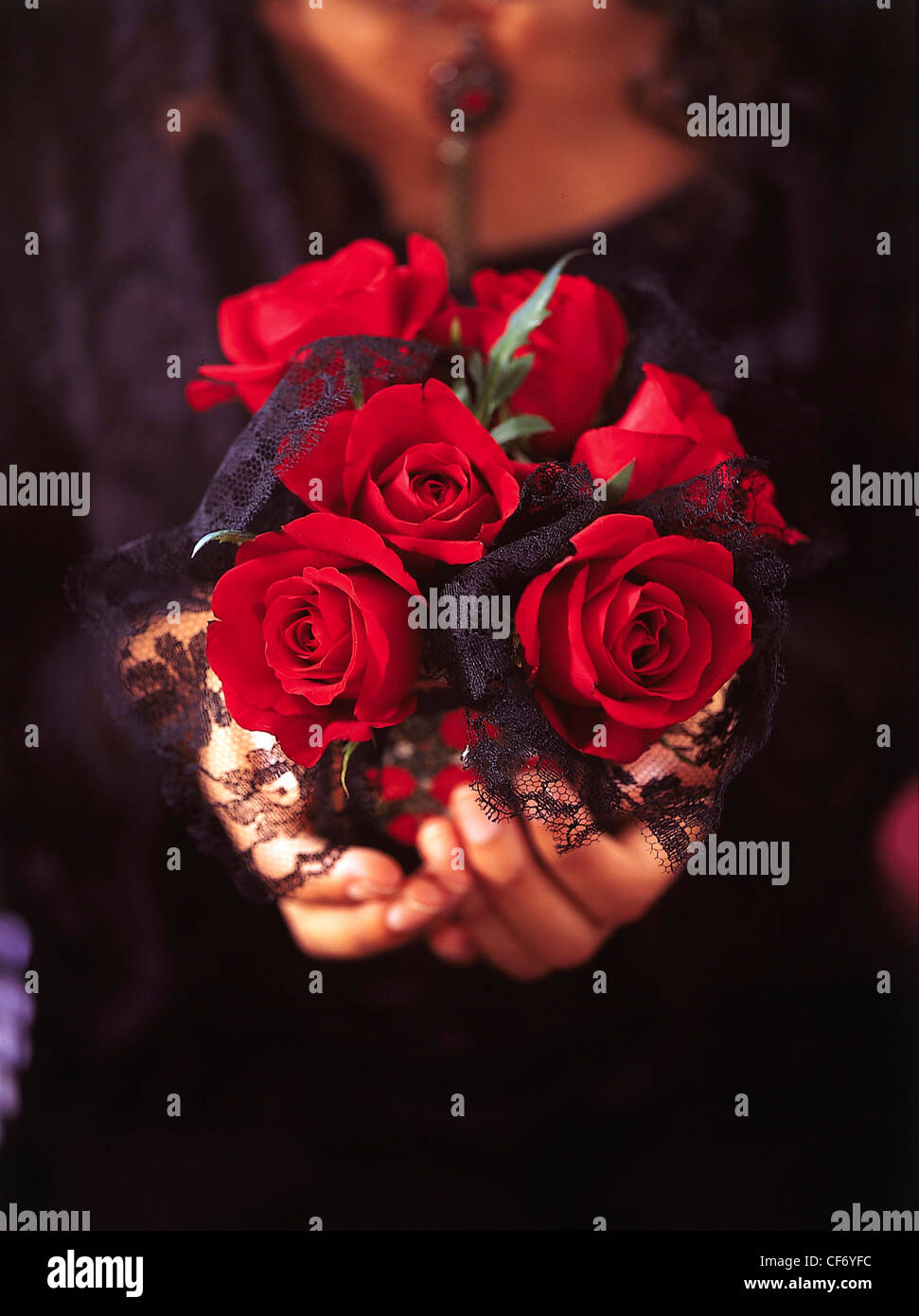 Red roses and black lace in a bouquet held in cupped hands Stock Photo ...